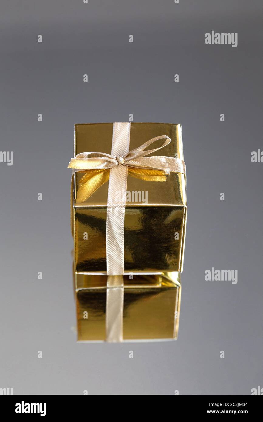 Group of gold sparkling gift boxes on grey background with reflection ...