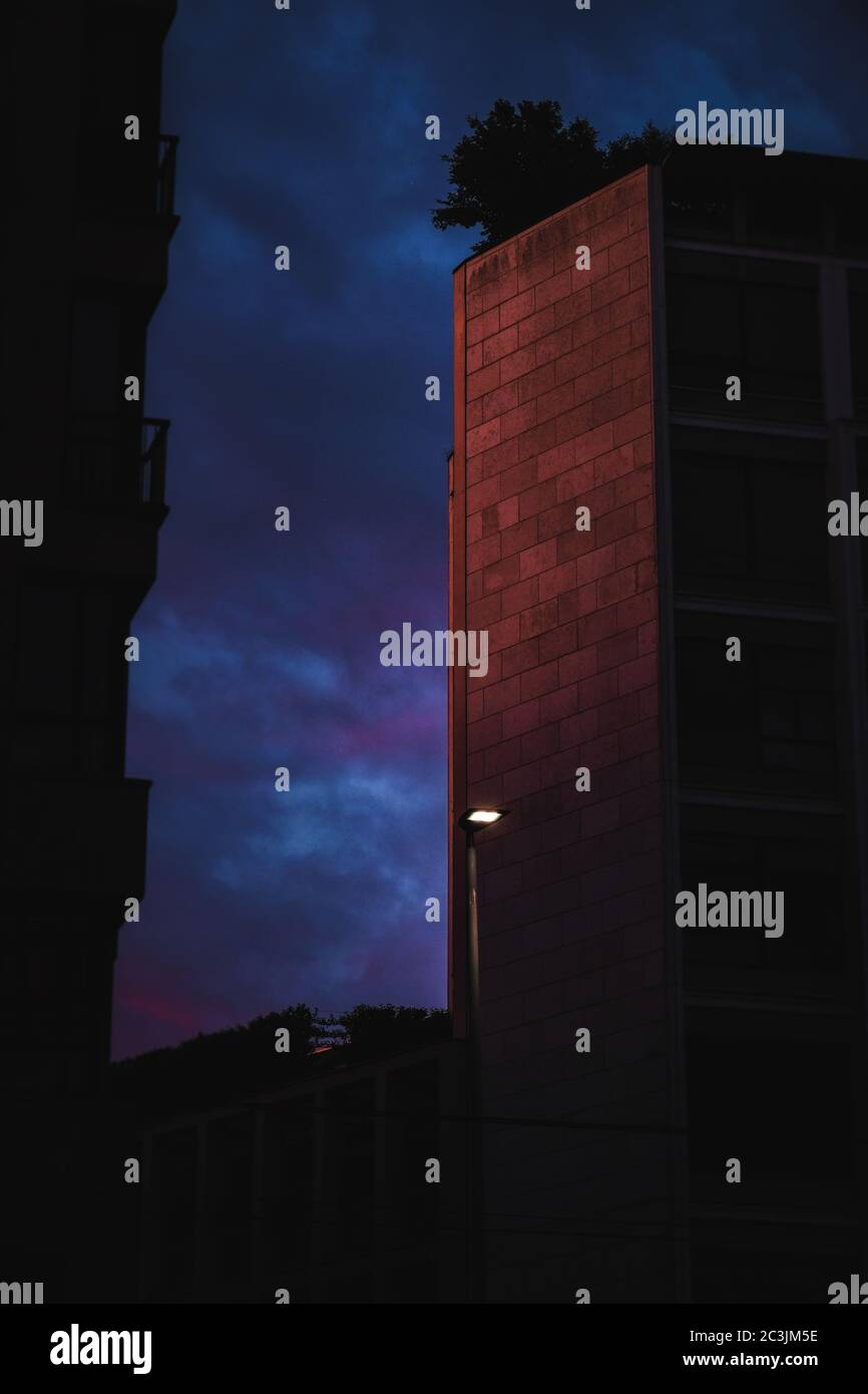 Vertical shot of a modern building with stone facade on a deep sunset ...