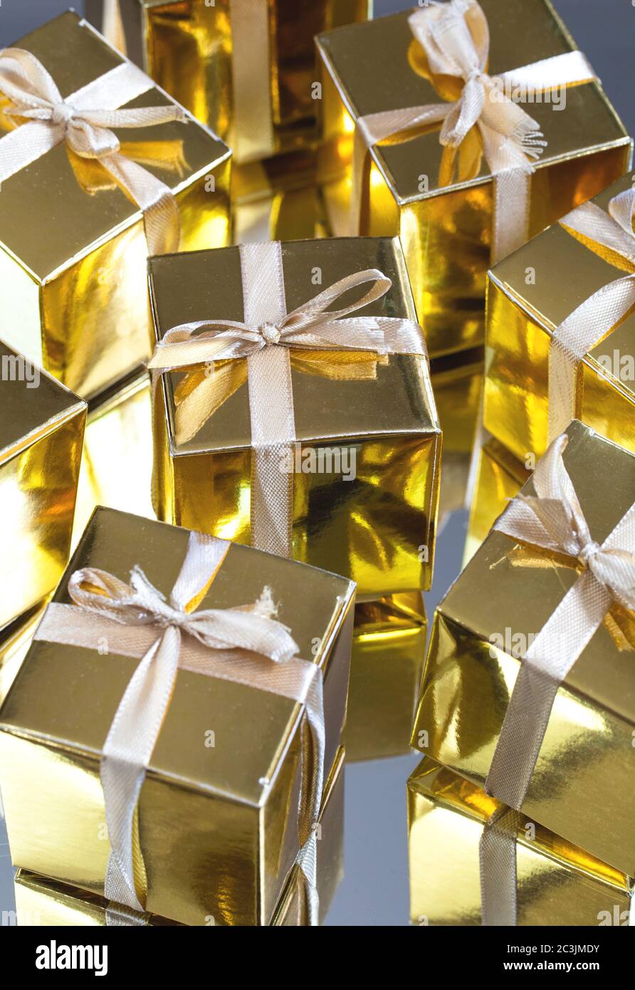 Group of gold sparkling gift boxes on grey background with reflection ...
