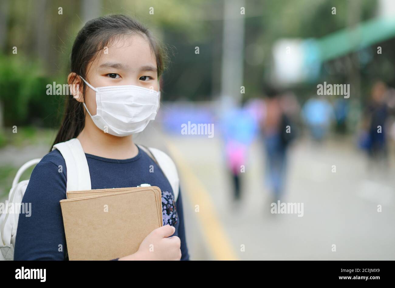 Back to school. asian child girl wearing face mask with backpack going ...