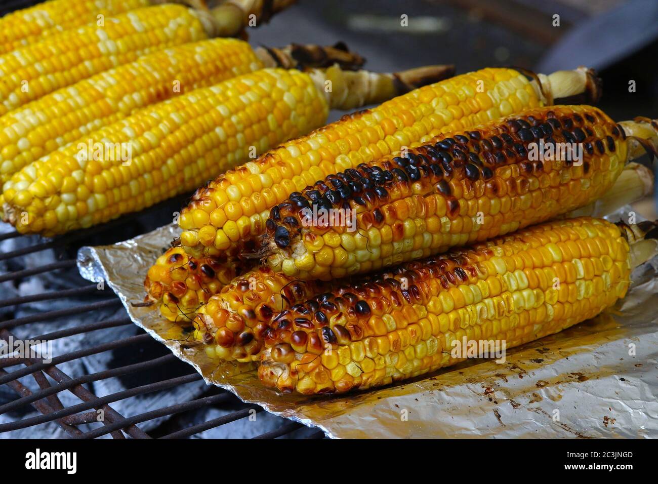Grilled corn on the cob on a foiled covered grill Stock Photo - Alamy