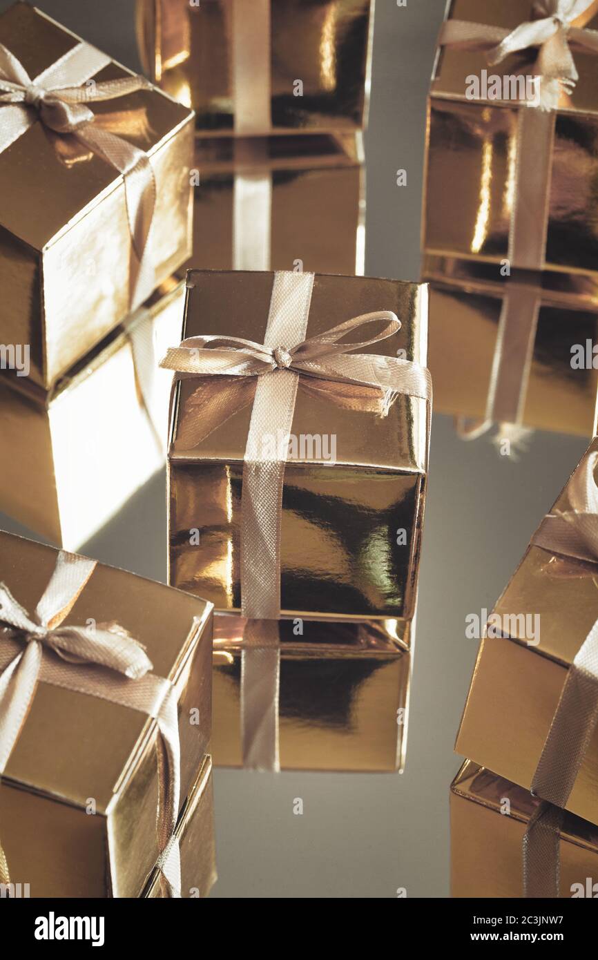 Group of gold sparkling gift boxes on grey background with reflection ...