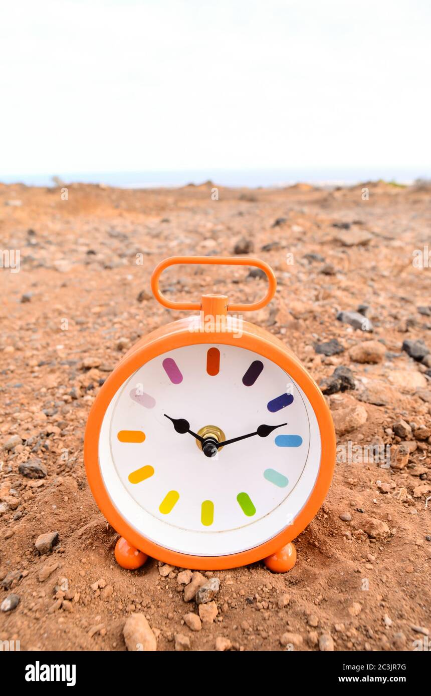 Classic Analog Clock In The Sand On The Rock Desert Stock Photo - Alamy