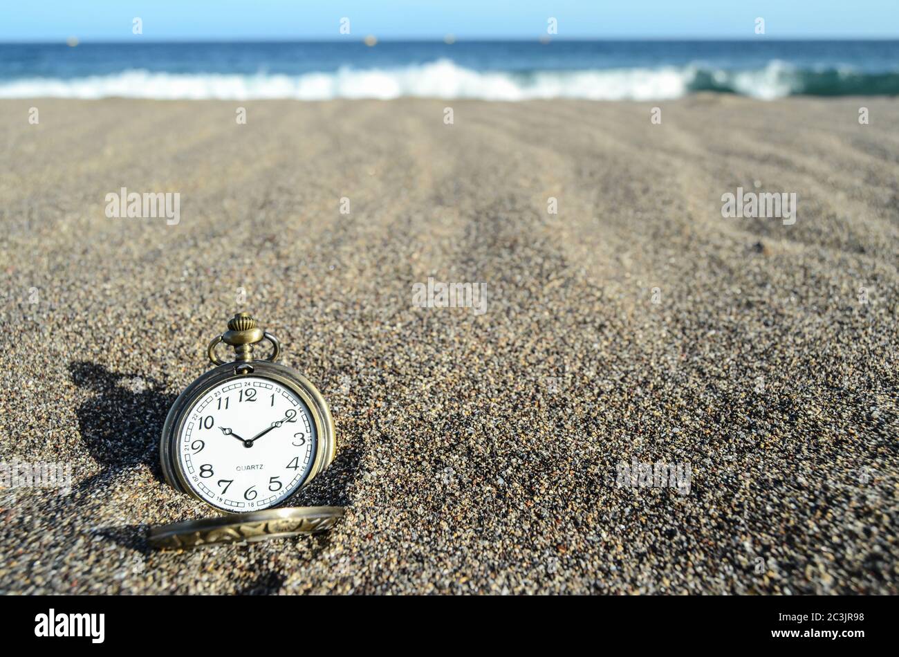 Classic Analog Clock In The Sand On The Beach Near The Ocean Stock ...