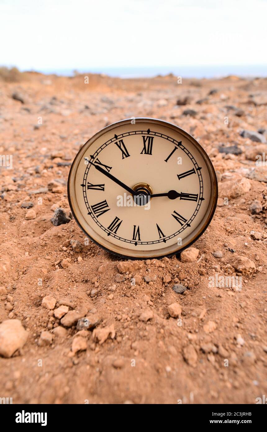 Classic Analog Clock In The Sand On The Rock Desert Stock Photo - Alamy