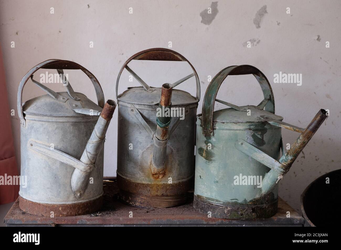 Three rusty metal kettles in the old building Stock Photo - Alamy