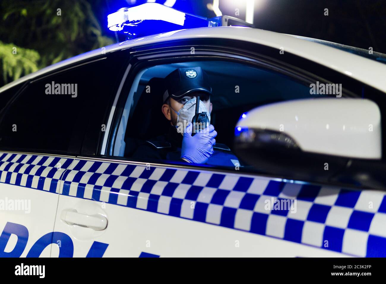 Closeup shot of a policeman with medical face mask driving police car ...