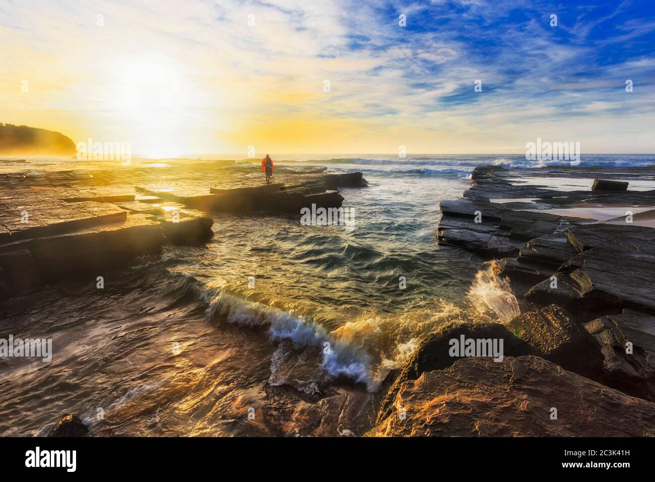 Scenic trench in sandstone plateau of Turimetta beach at sunrise with ...