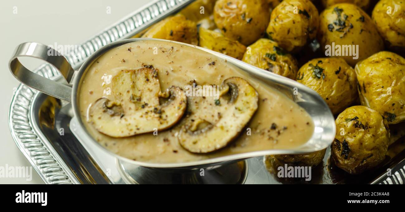 Mini jacket potatoes with mushrooms sauce on the silver tray, delicious ...