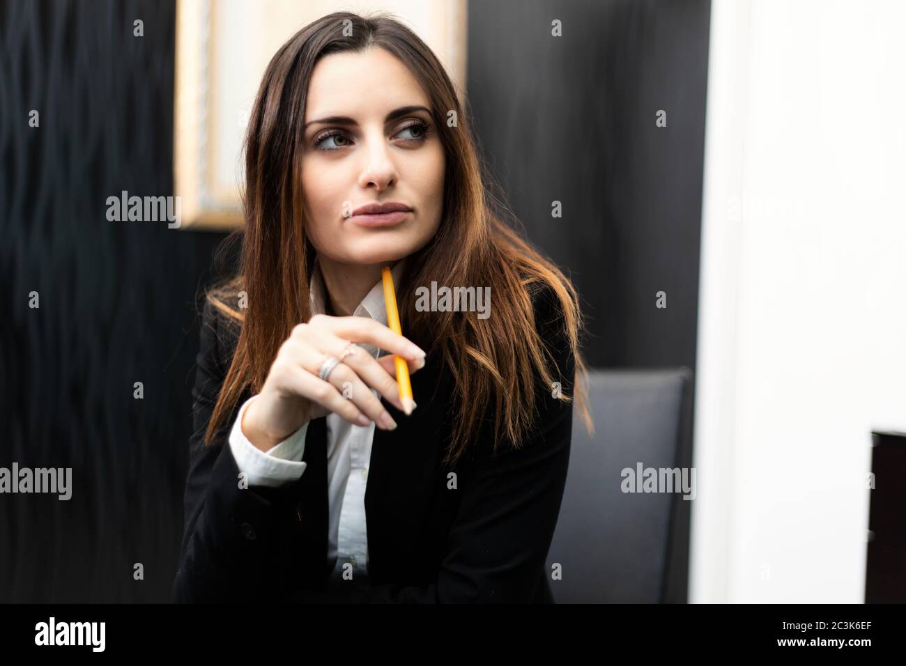 Young female manager sitting a ther desk in a modern office in a ...