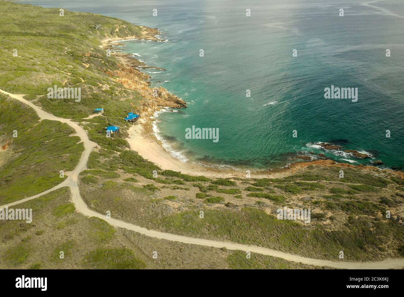 Bird's-eye view of a seashore with pure turquoise water and lodges ...