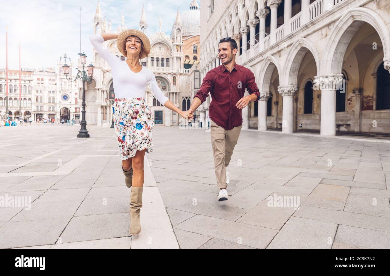 Romantic couple in love running in the city of Venice, Italy. Man and ...