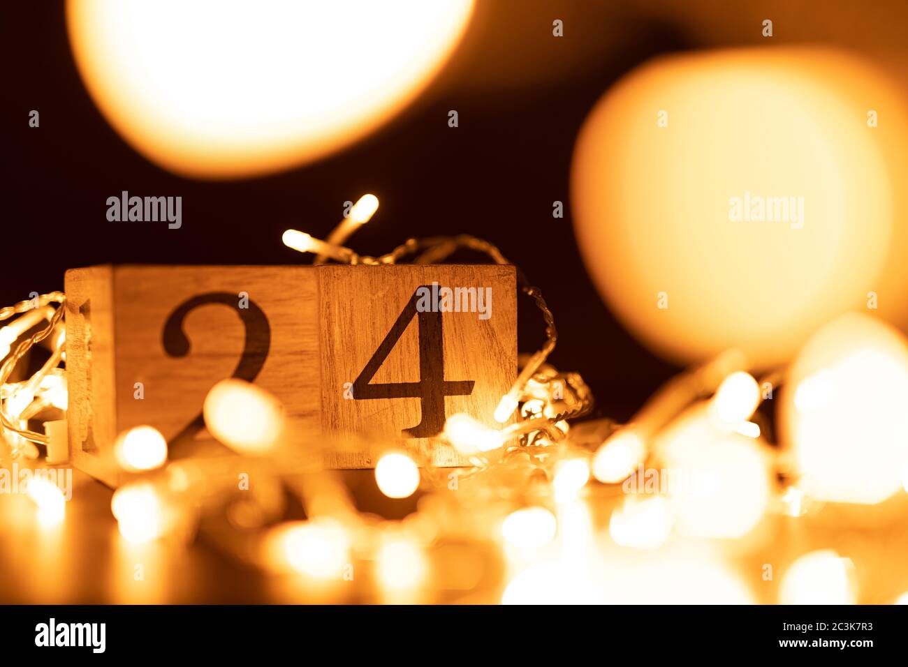 The number [24] written with cubes surrounded by Christmas lights on a ...