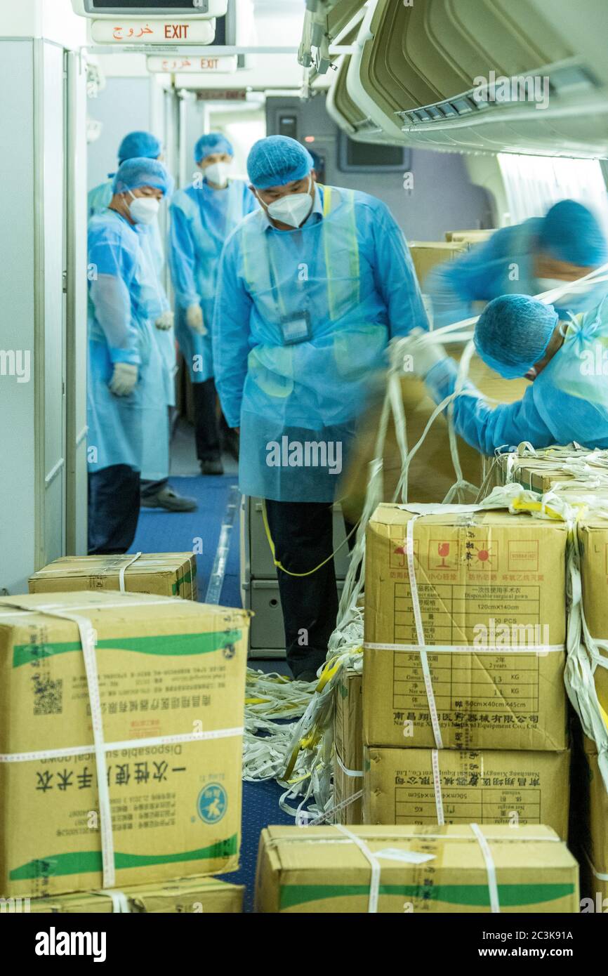 Chinese loaders wearing hazmat suits loading a converted passenger into ...
