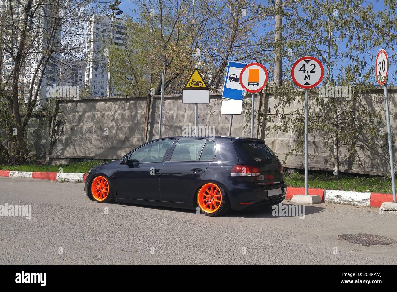 Black hatchback with orange wide wheels tuned by air suspencion parked ...