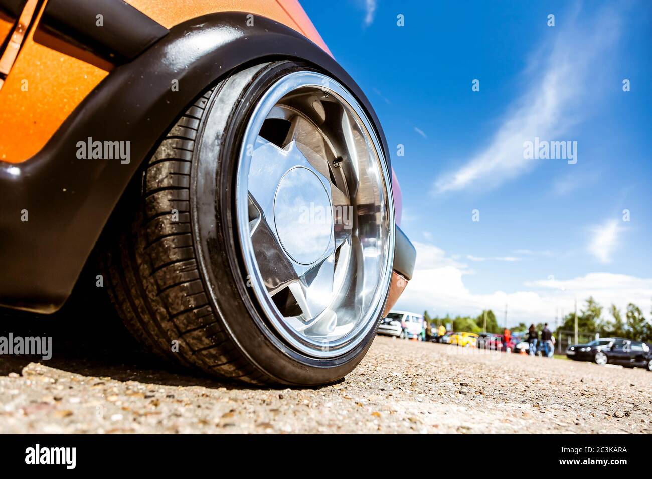 Mirror polished tuned wheels mounted on an understated orange car ...
