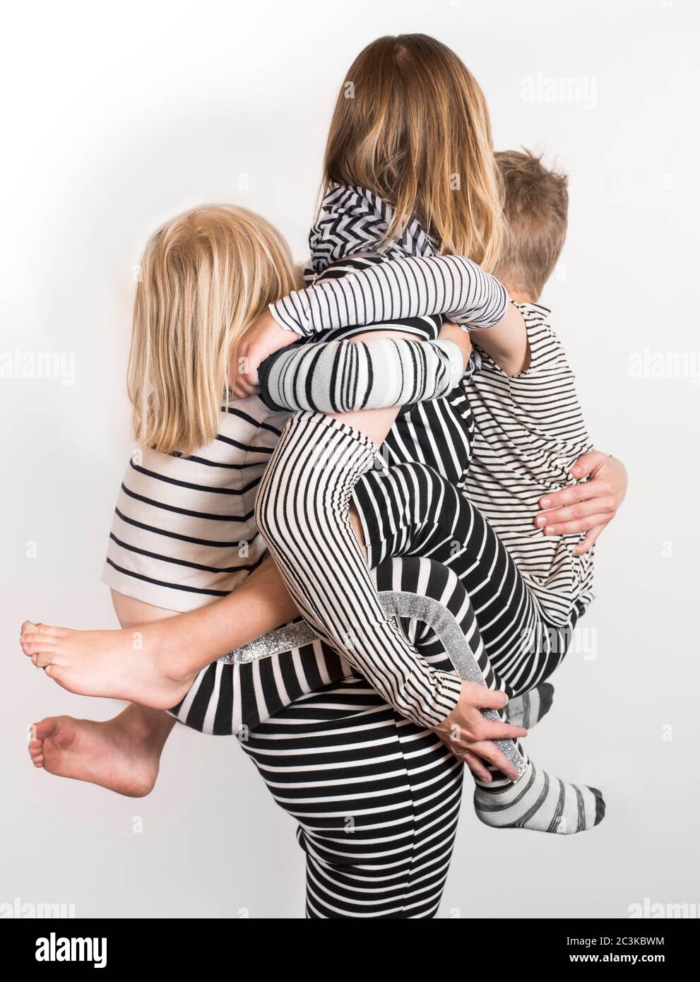 A mom holds up her two young kids, and the stripes on their clothing ...