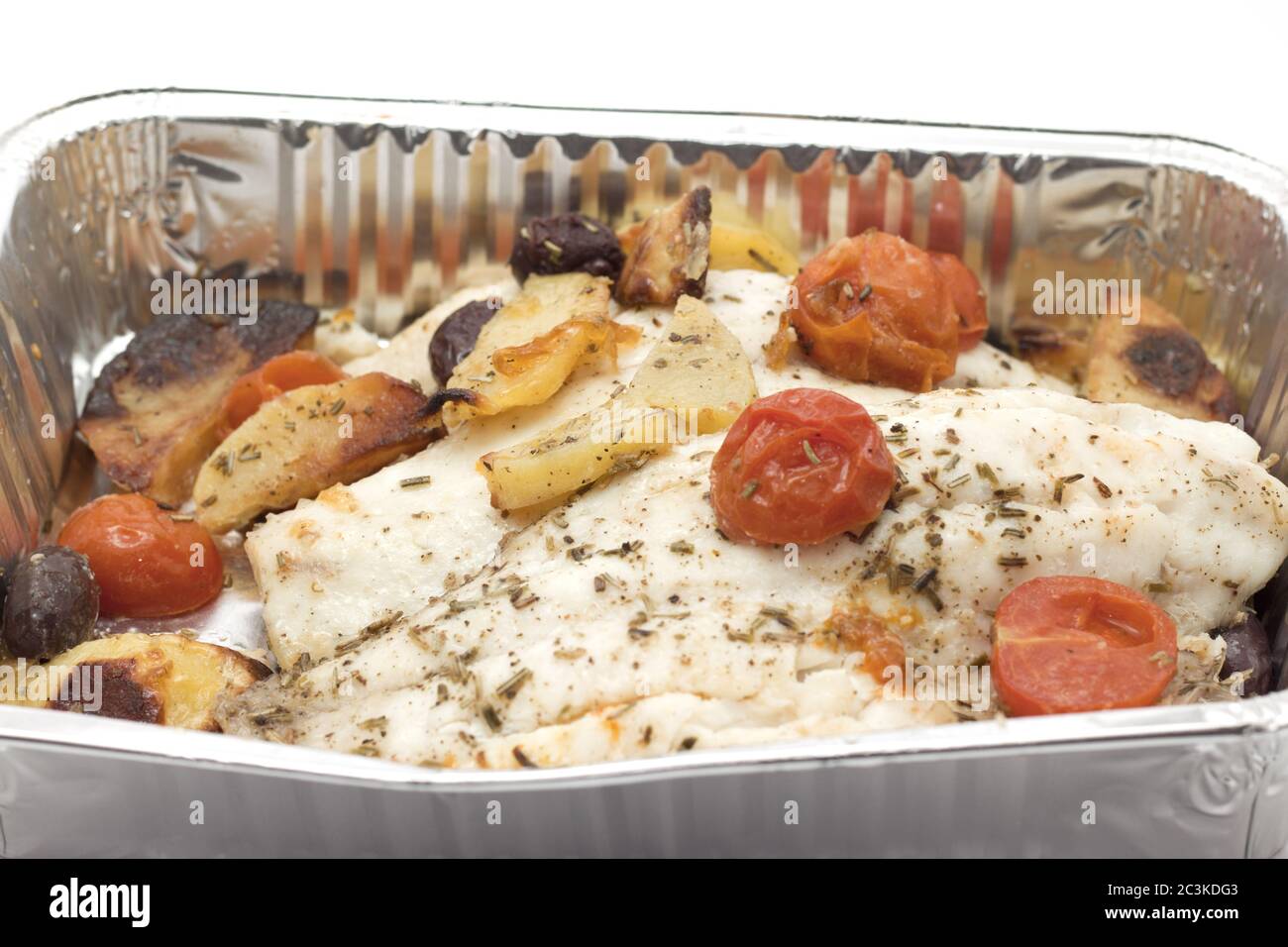 Perch fillet steamed with cherry tomatoes in a foil box isolated on a ...