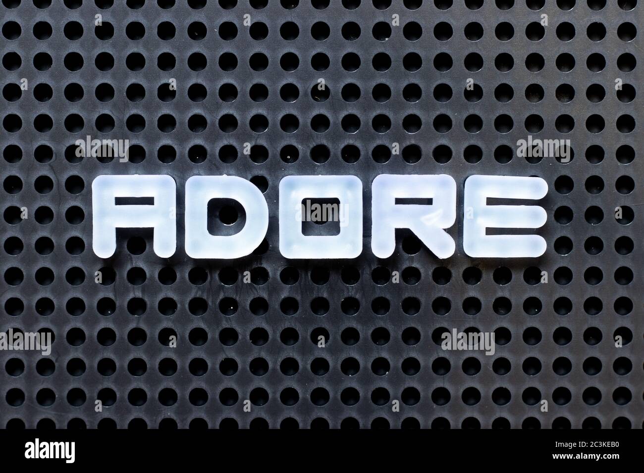 White color alphabet with word adore on black pegboard background Stock ...