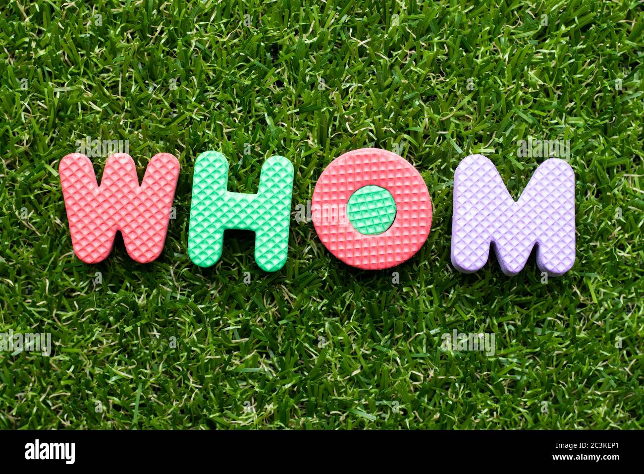 Toy foam letter in word whom on green grass background Stock Photo - Alamy