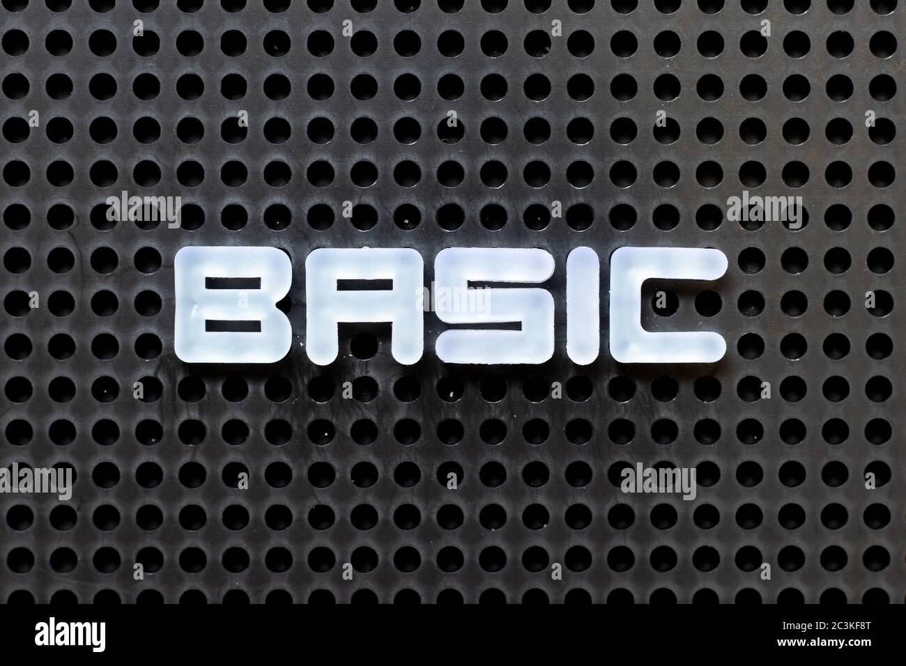 White color alphabet with word basic on black pegboard background Stock ...