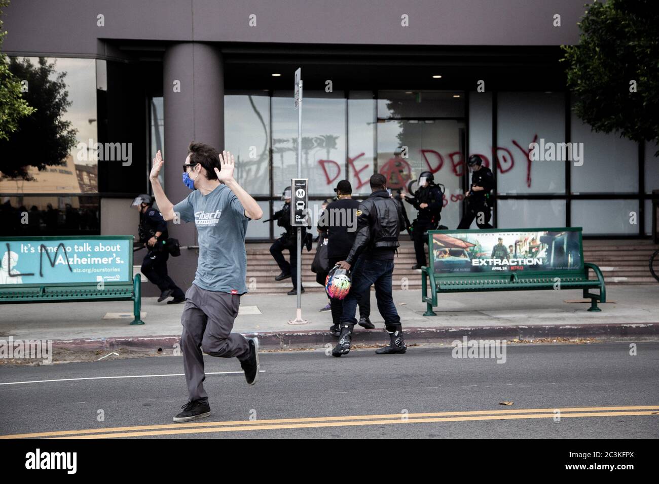 A man runs away with his hands up as LAPD riot police charge toward ...