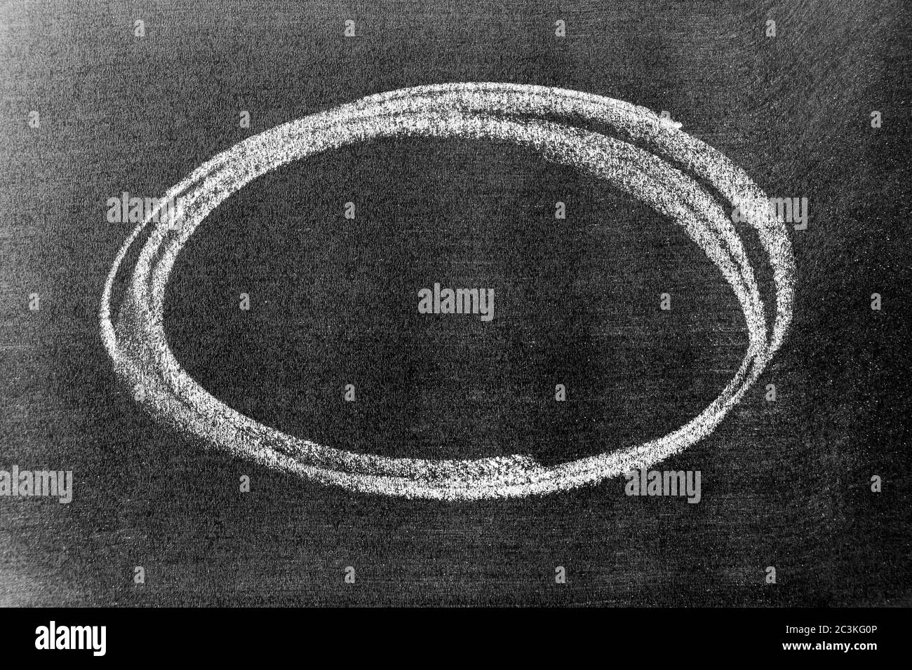 White color chalk hand drawing in circle or oval shape on black board ...
