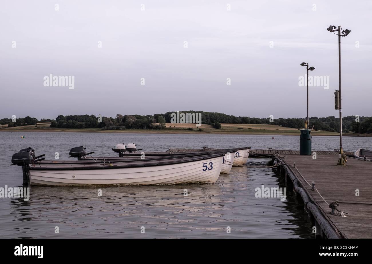 Three white boats on a pier with a gray sky in the background Stock ...