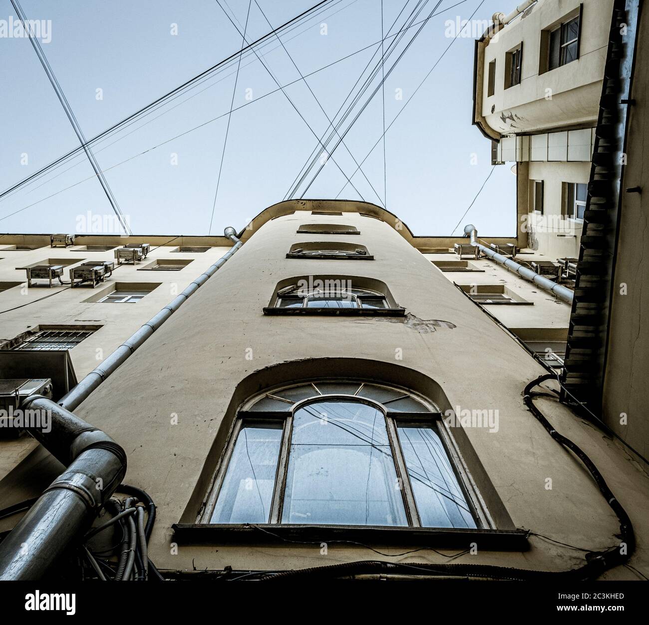 Low angle shot of a building with arch-shaped windows under the blue ...