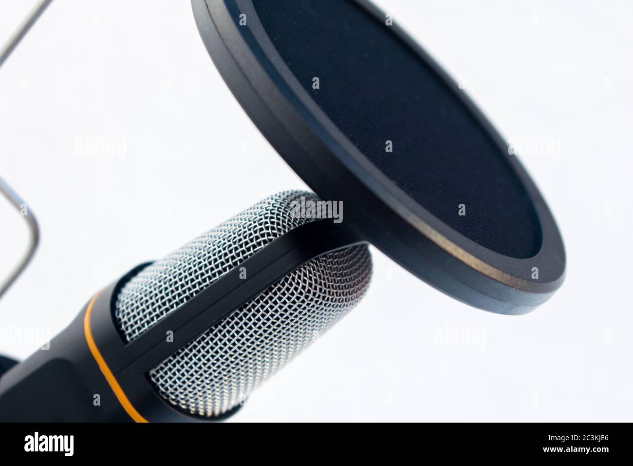 Closeup of a black and grey microphone captured on a white background ...