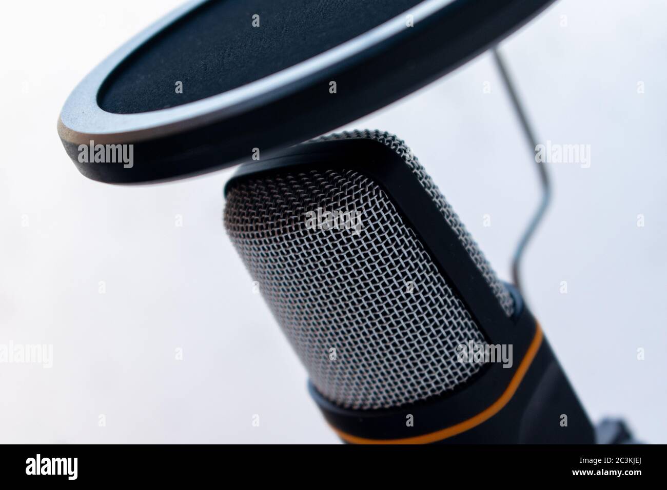 Closeup of a black and grey microphone captured on a white background ...