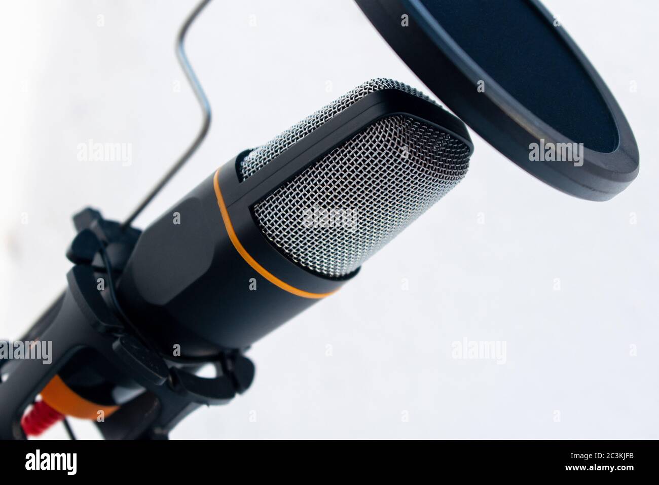 Closeup of a black and grey microphone captured on a white background ...