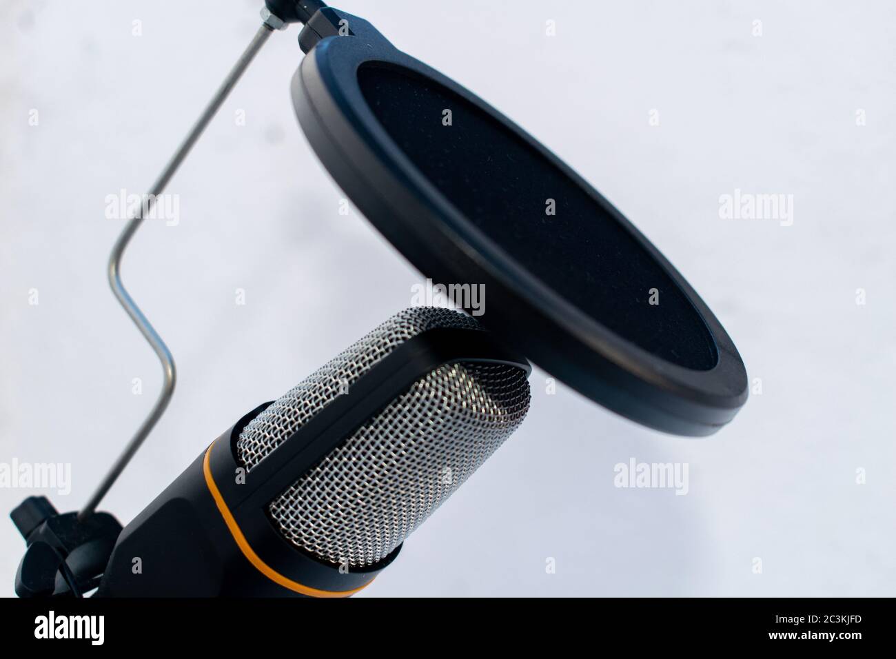 Closeup of a black and grey microphone on a white surface and ...