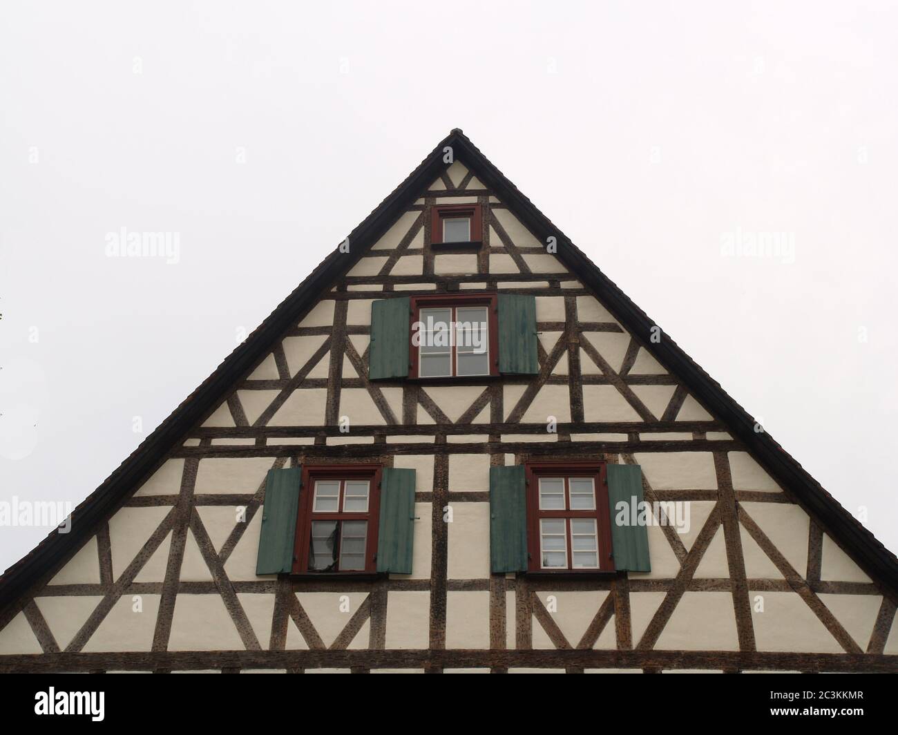 Low angle shot of a half-timbered A-frame house roofing with windows ...
