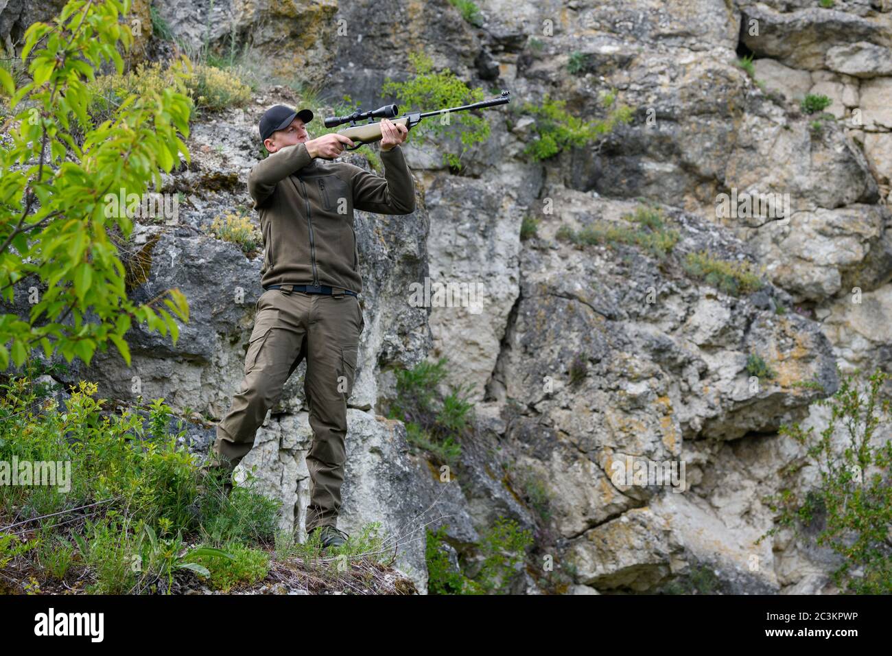 Close male with a gun in hunting period. Hunter in camouflage clothes ...