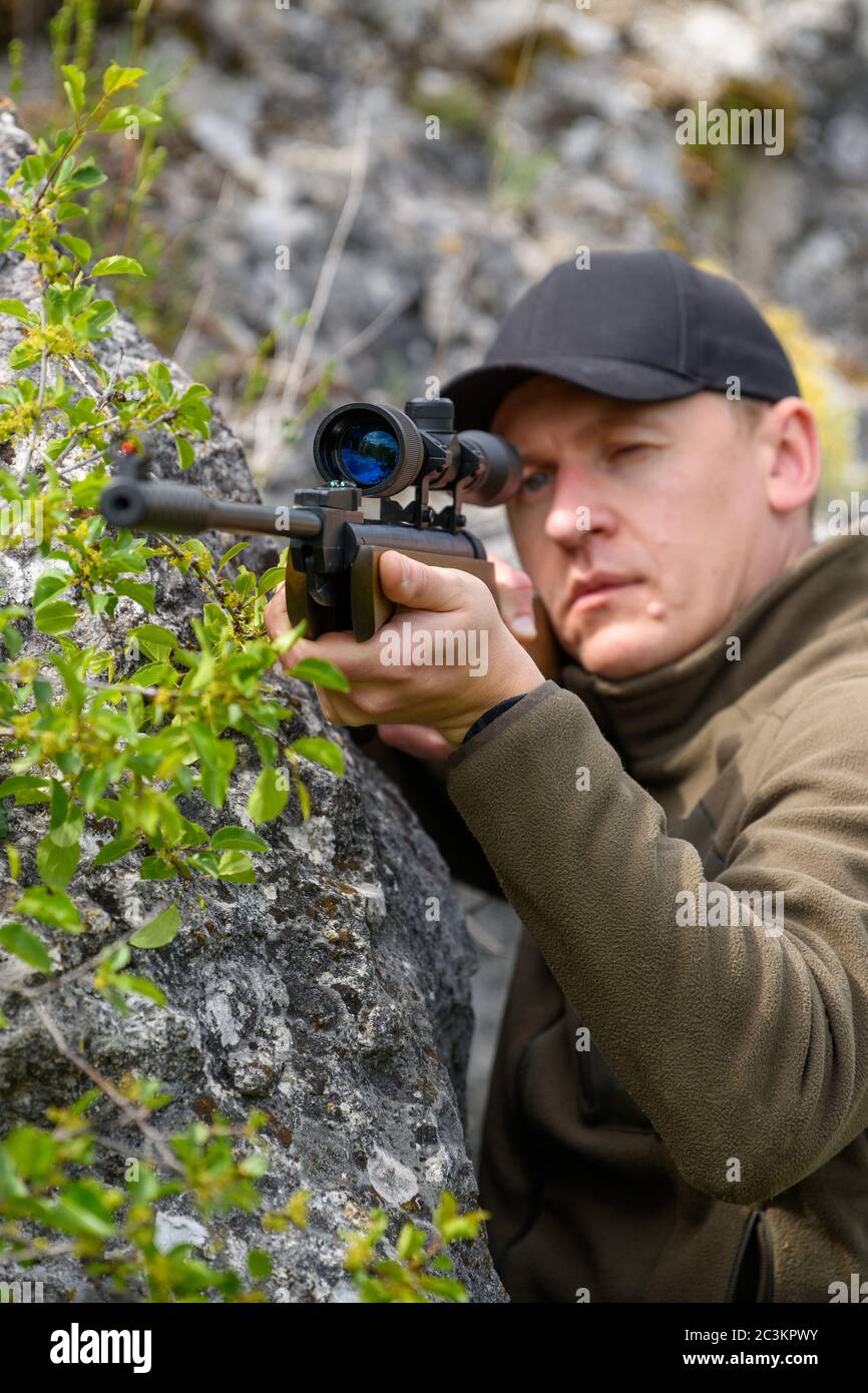 Close male with a gun in hunting period. Hunter in camouflage clothes ...