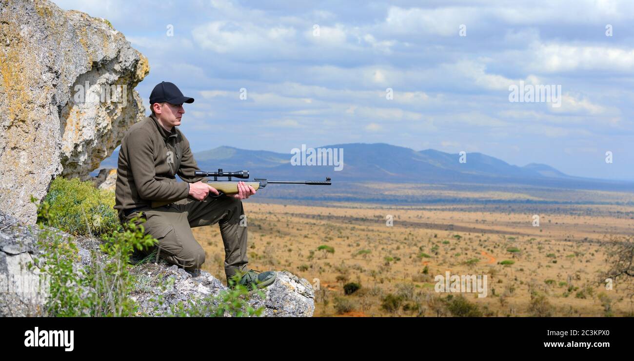 Close male with a gun in hunting period. Hunter in camouflage clothes ...