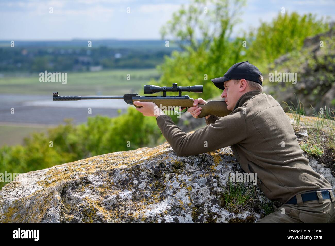 Close male with a gun in hunting period. Hunter in camouflage clothes ...