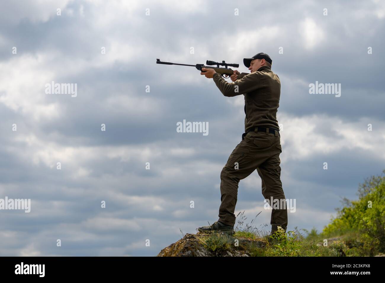 Close male with a gun in hunting period. Hunter in camouflage clothes ...
