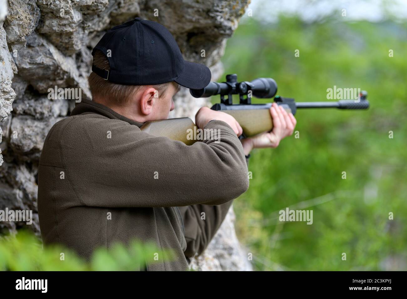 Close male with a gun in hunting period. Hunter in camouflage clothes ...
