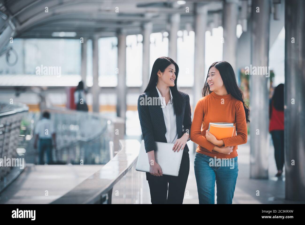 Diversity Teenagers holding laptop computer and a book walking at the ...