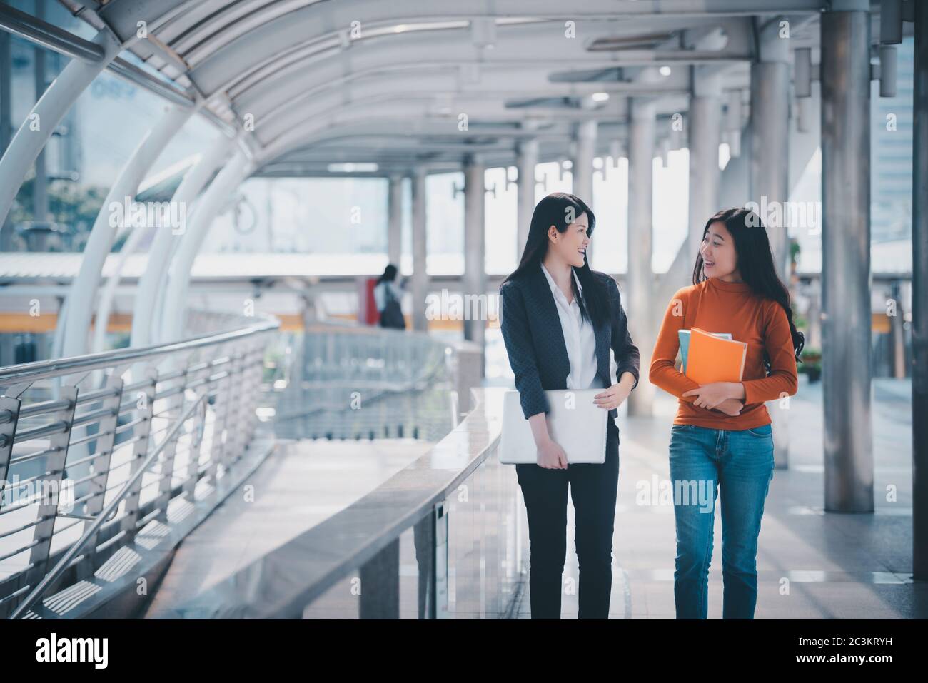 Diversity Teenagers holding laptop computer and a book walking at the ...
