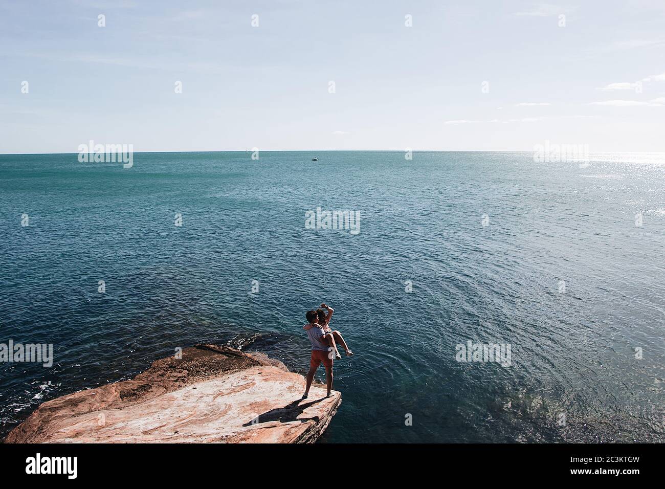 Man holding a woman and standing on the edge of a cliff Stock Photo - Alamy