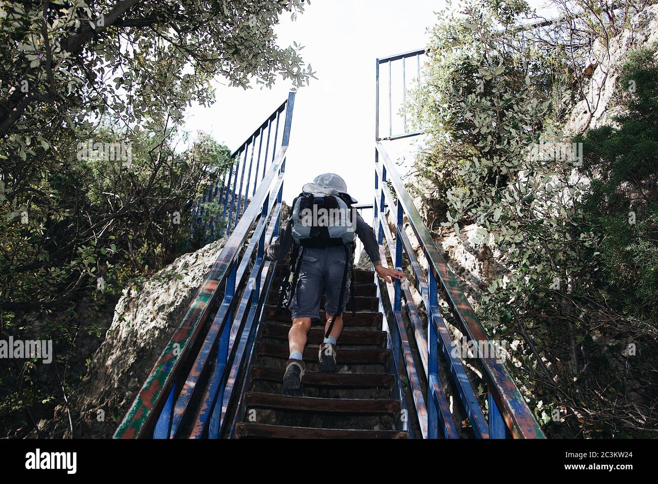 Person with a backpack going up with stairs Stock Photo - Alamy