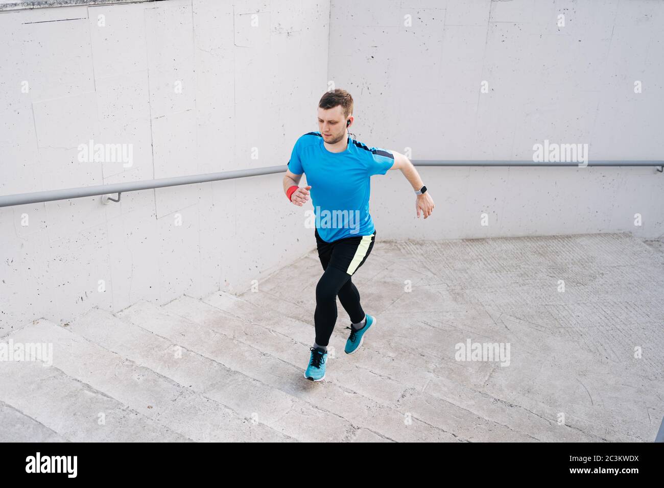 Young man running upstairs on city stairs. Fitness, sport, people ...