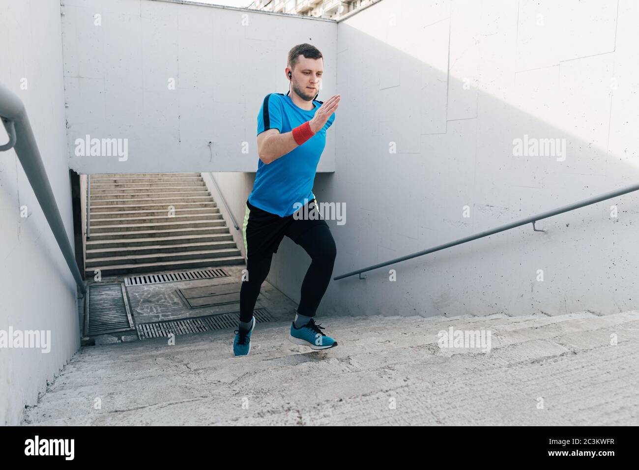 Young man running upstairs on city stairs. Fitness, sport, people ...