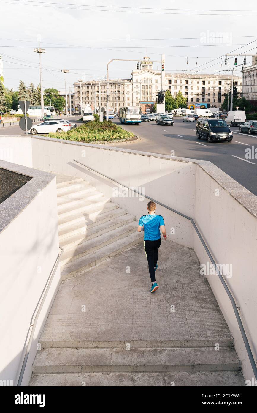 Young man running upstairs on city stairs. Fitness, sport, people ...