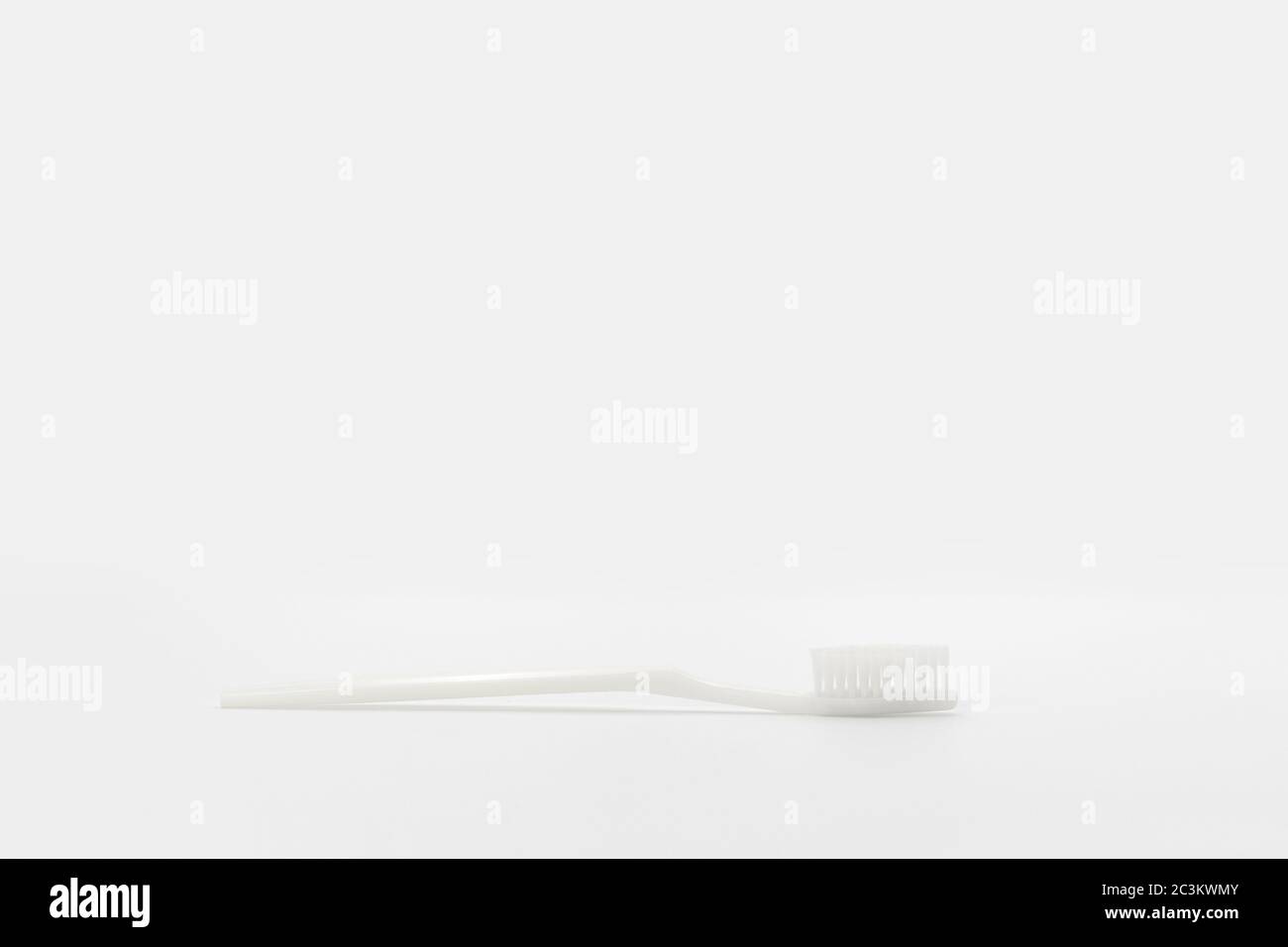 Isolated simple normal white toothbrush is laid on the white background ...