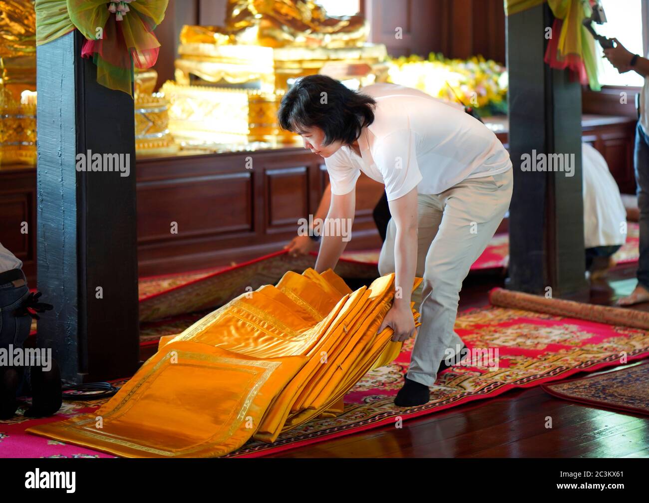Asian Man supports and prepares orange monk seat on the red carpet in ...