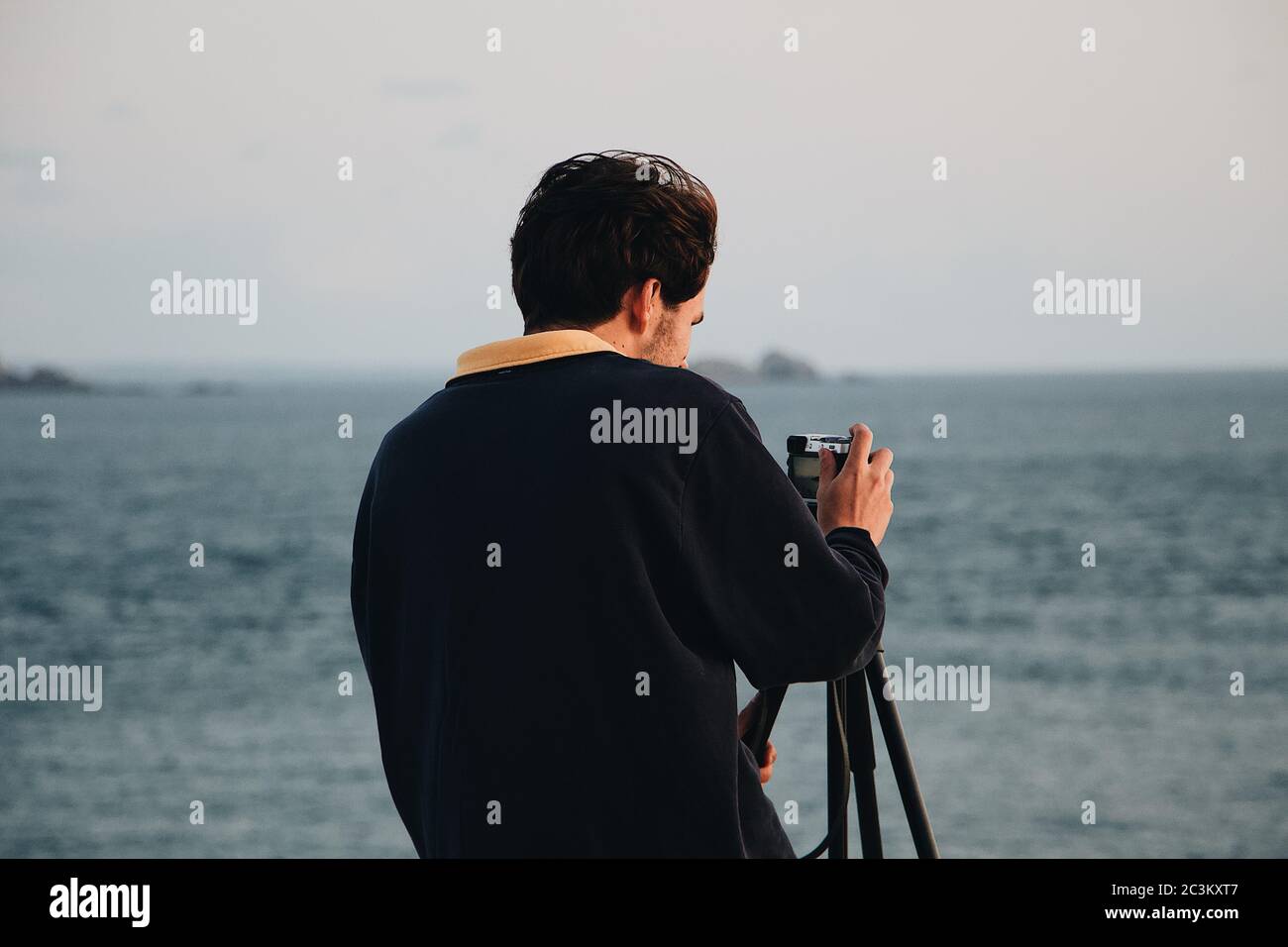 Young man capturing the seascape Stock Photo - Alamy